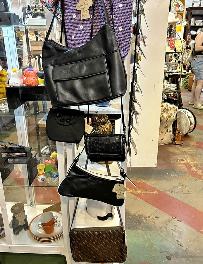 Vintage handbags hang in patient formation, their classic designs proving that good style transcends trends – each one waiting for its second act.