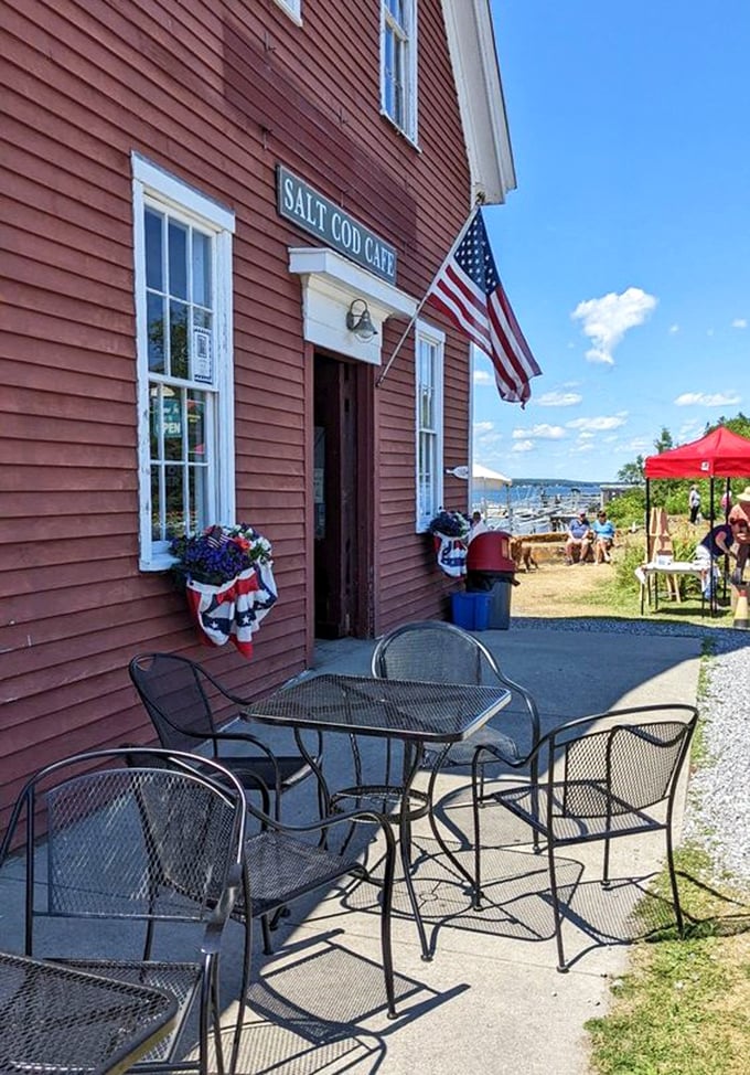 Outdoor seating with American flag proudly displayed &ndash; quintessential Maine, where patriotism and breathtaking views come standard with your breakfast sandwich.