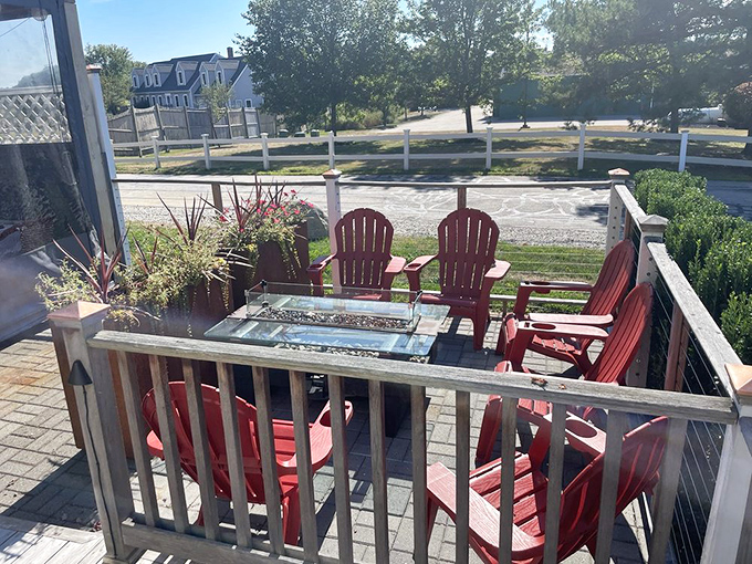 Red Adirondack chairs gather around a fire feature &ndash; Maine's version of paradise on a warm summer evening.