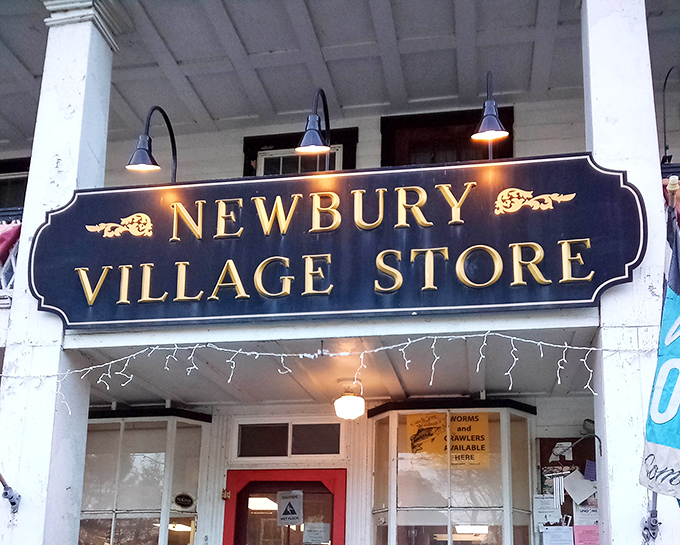 Illuminated by vintage-style lamps, the Newbury Village Store sign glows like a beacon for hungry travelers on Vermont's rural roads.