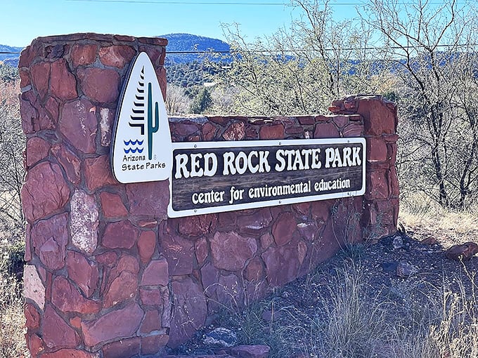 The park's entrance sign welcomes nature lovers, its stone base and wooden plaque promising adventures in Arizona's red rock country.