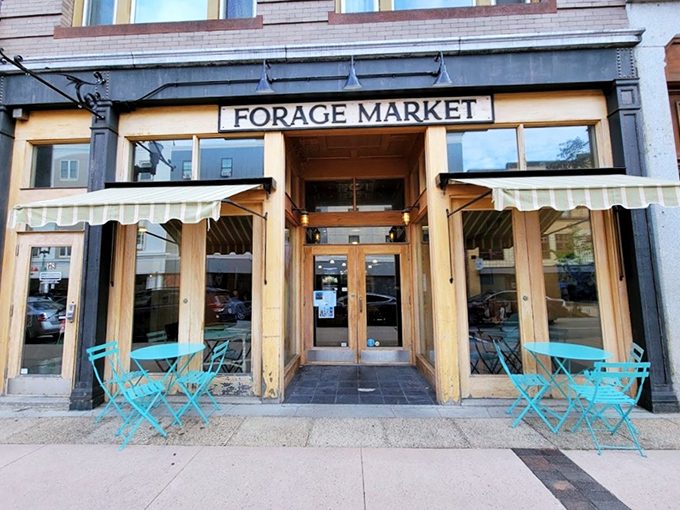 Morning light bathes the welcoming entrance, where those turquoise chairs promise relaxation and exceptional bagel experiences await.