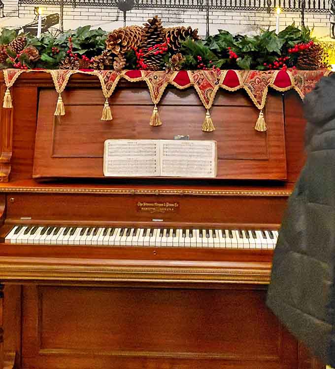 Sheet music waits eternally on this antique piano, ready for phantom fingers to play melodies that once filled these rooms with life and emotion.