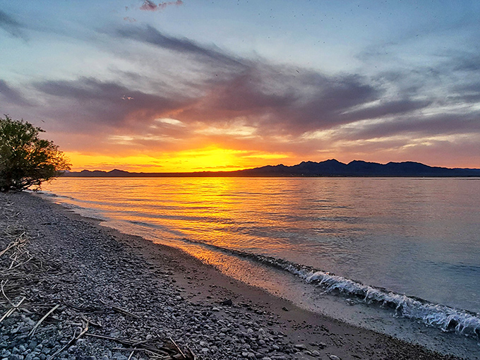 The sun bids farewell in a spectacular display of color, painting the water with liquid gold that makes everyone pause in wonder.
