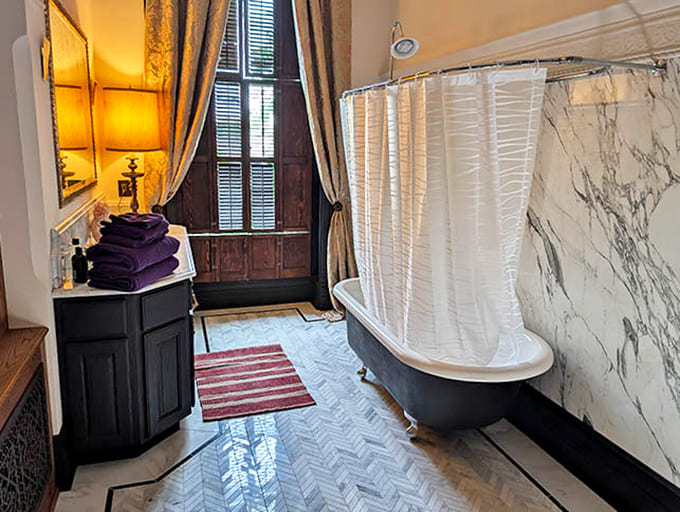Natural light bathes this classic bathroom, where marble surfaces and thoughtful details elevate the simple act of bathing into a pleasure.