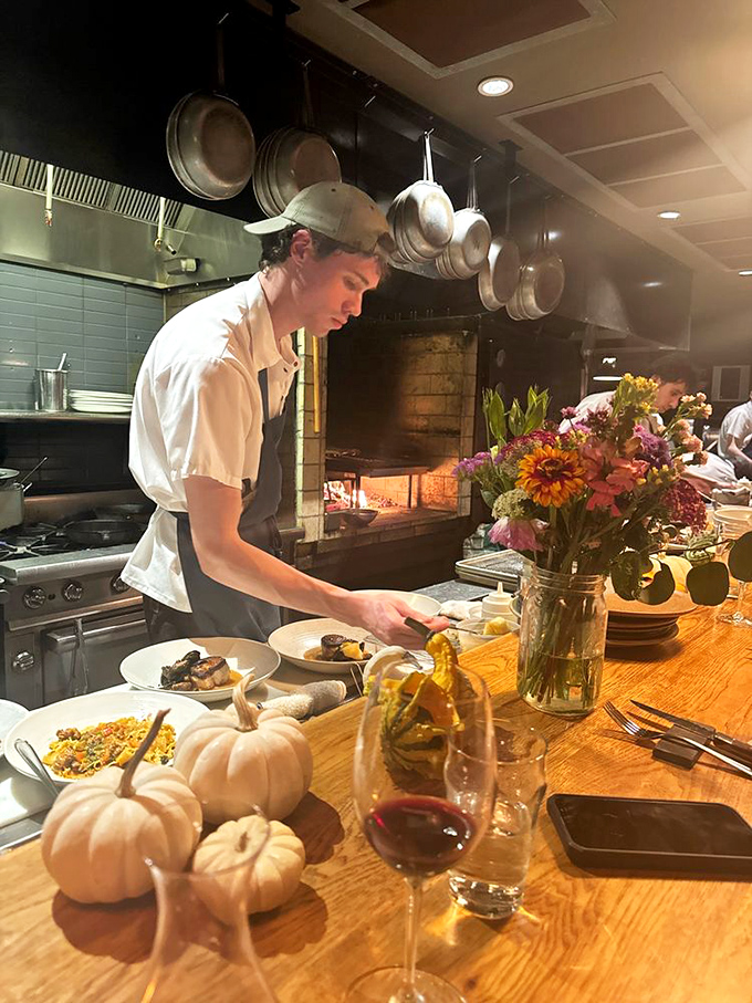 A chef carefully plates a dish amid seasonal decorations – where every plate is a canvas and Vermont's bounty provides the palette.