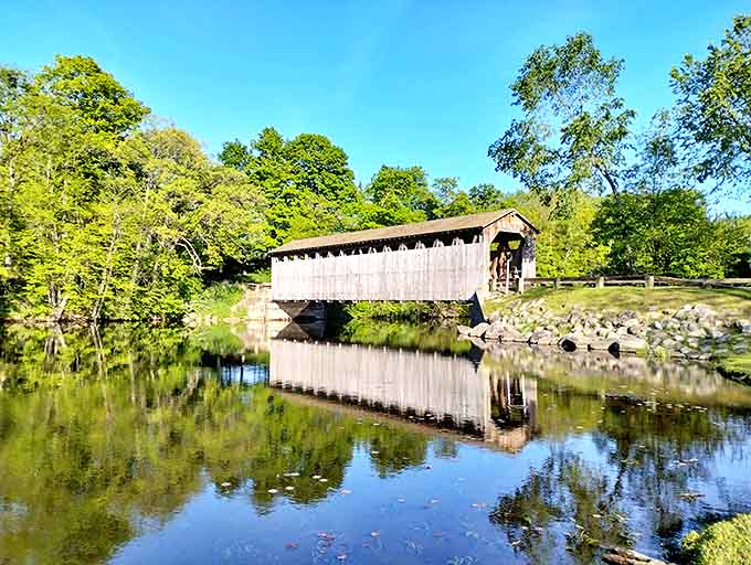 The covered bridge creates a perfect reflection in still waters, doubling the beauty of this historic Michigan treasure.