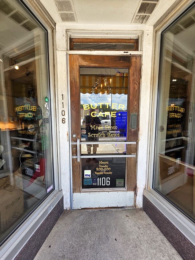 Entrance: The wooden door with "Butter Cafe" in golden lettering &ndash; a portal to a world where breakfast is never boring.