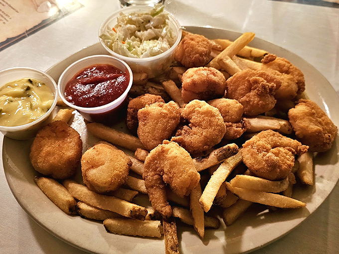 Golden-fried seafood and crispy fries share plate space in perfect harmony &ndash; comfort food elevated by fresh ingredients and careful preparation that respects the catch.