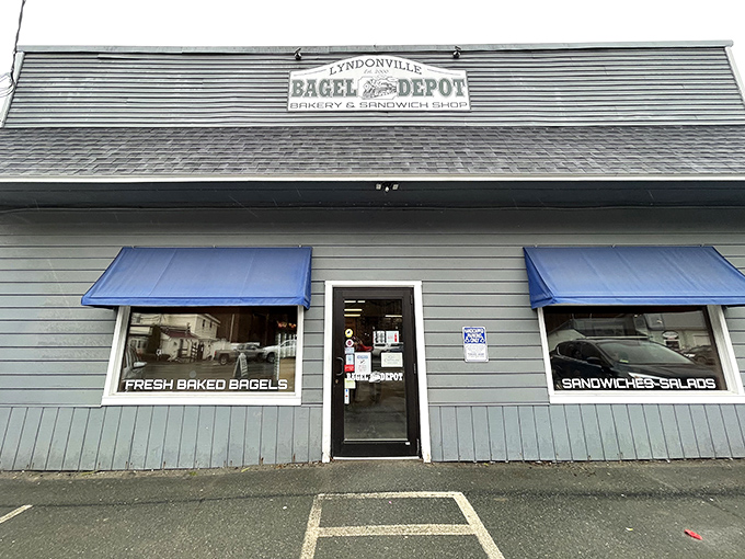 Front: The final approach to flavor town – blue awnings and simple signage marking the spot where bagel memories are made. Vermont's humble treasure.
