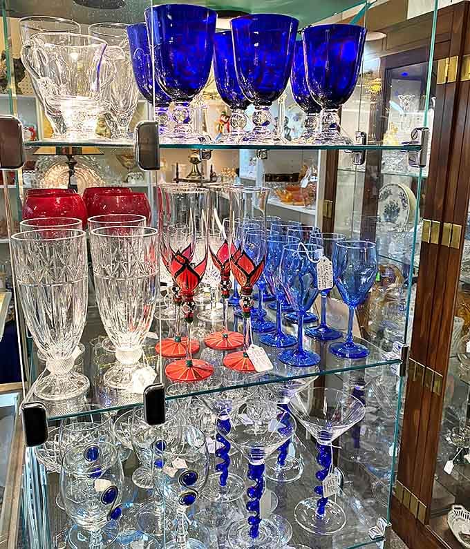 Colorful glassware in red, blue, and crystal catches your eye, each piece a tiny celebration of craftsmanship and style.