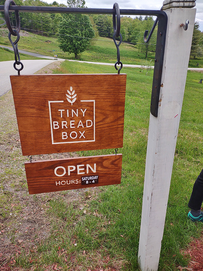 The rustic wooden sign swings gently in the breeze, announcing limited hours that make each Saturday visit feel like a special occasion.