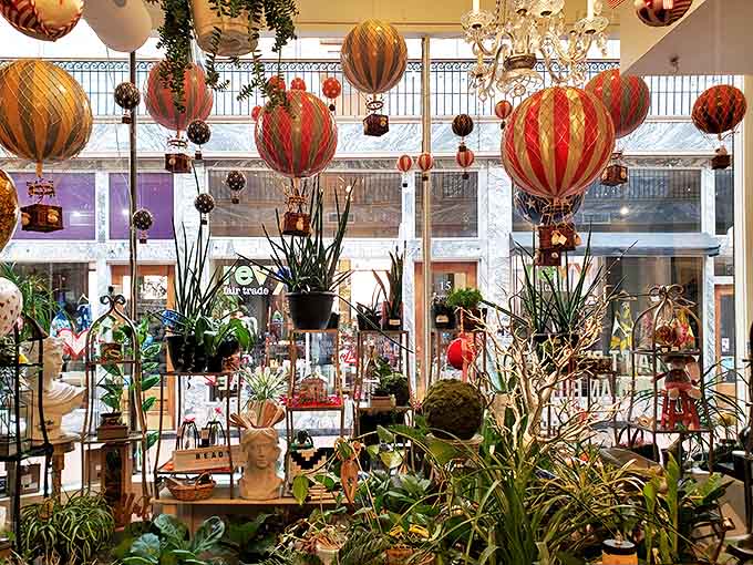 Whimsical hot air balloons float above an indoor garden &ndash; a colorful aerial display that adds vertical drama to this plant-filled paradise.