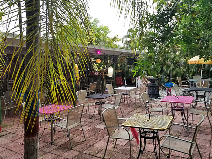 The outdoor patio offers a tranquil escape among palm fronds and colorful tables &ndash; Florida dining at its most relaxed.