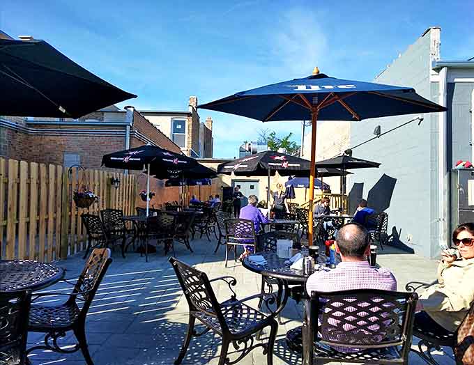 Gather your friends for a relaxing afternoon on this sun-drenched patio, featuring plenty of comfortable seating under breezy blue umbrellas.