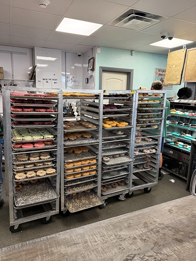 Those racks of fresh donuts waiting to be glazed and topped look like backstage at a beauty pageant, except every contestant is delicious and nobody's competing for world peace.