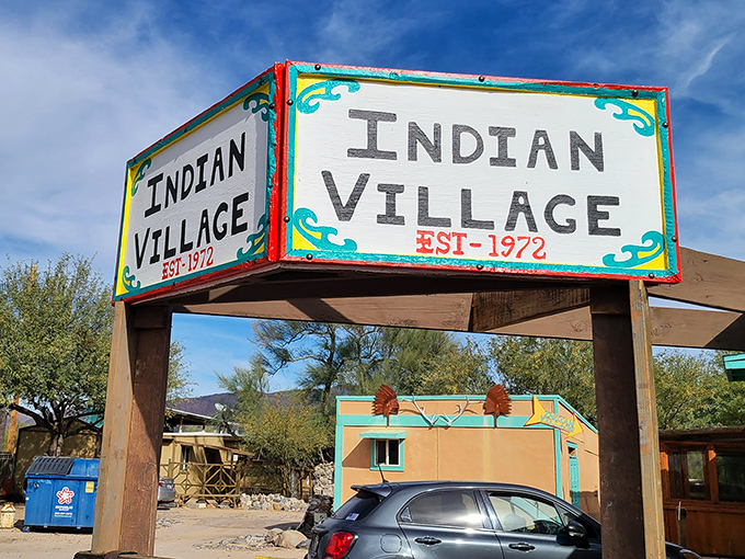 The iconic Indian Village sign stands as a beacon for hungry travelers, promising authentic Southwestern flavors in the heart of Cave Creek.