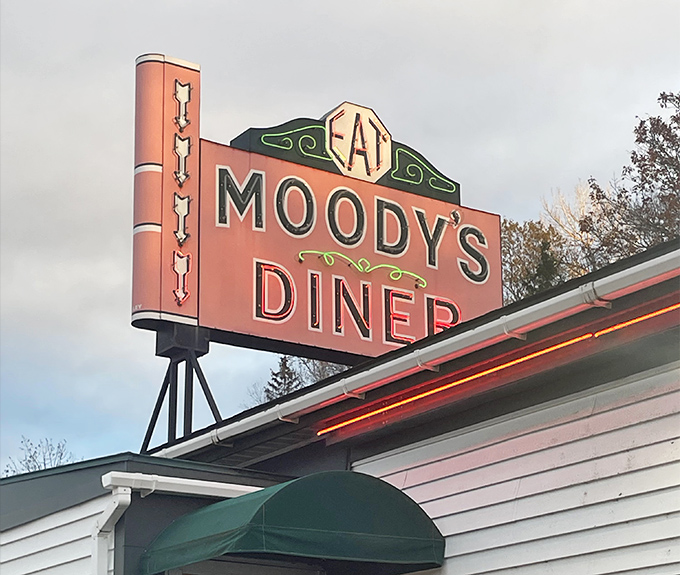 The iconic Moody's Diner sign stands tall against the Maine sky, a beacon of comfort food that's been guiding hungry travelers for generations.
