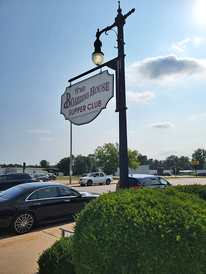 The iconic street sign swinging gently in the Wisconsin breeze, a beacon for hungry travelers seeking authentic supper club magic.