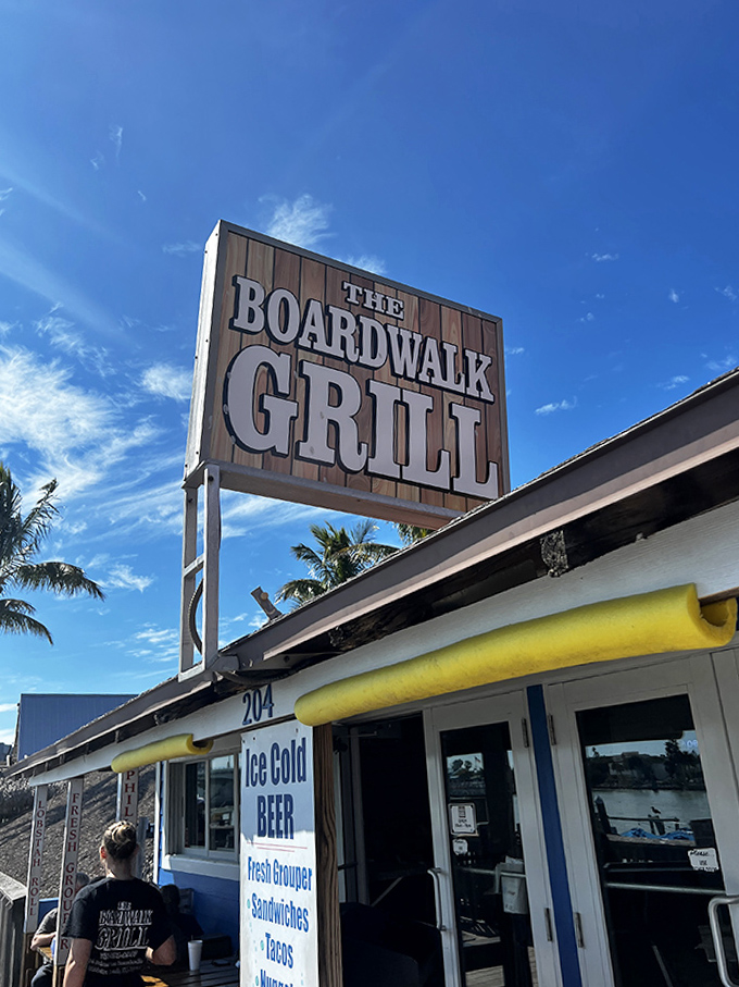 The iconic Boardwalk Grill sign stands against a perfect Florida sky, promising seafood dreams about to come true.