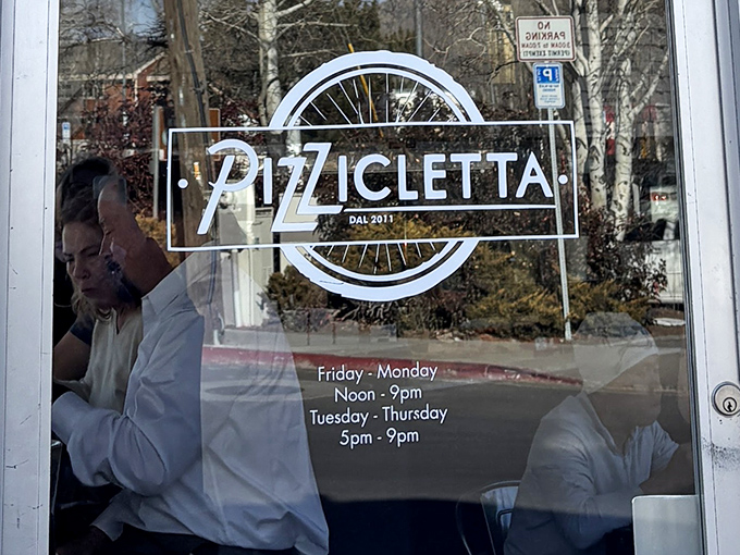 The bicycle wheel in Pizzicletta's logo nods to the Italian cycling journey that inspired this beloved Flagstaff institution.