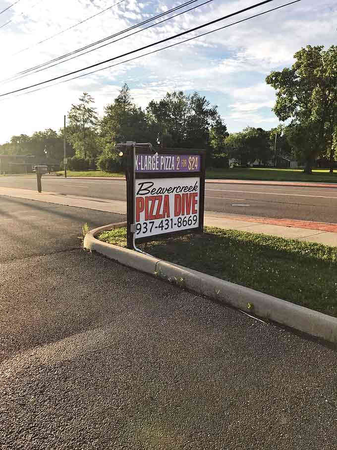 The roadside beacon that guides hungry travelers to pizza paradise, promising affordable delights that deliver far beyond their modest price point.