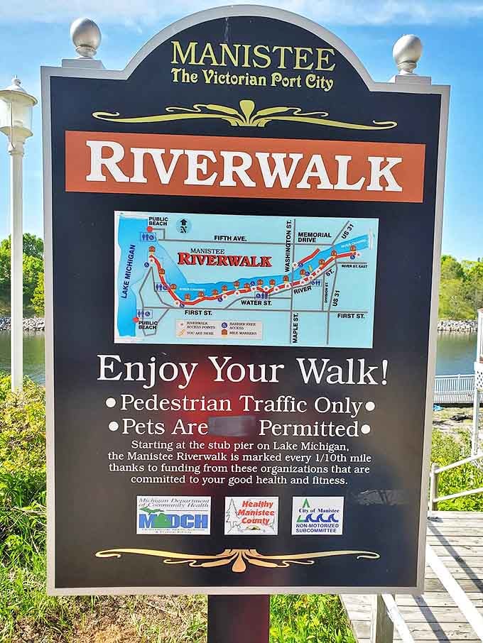 The official Riverwalk sign stands as a cheerful greeter, mapping out 1.75 miles of wooden-planked Michigan magic for eager explorers.