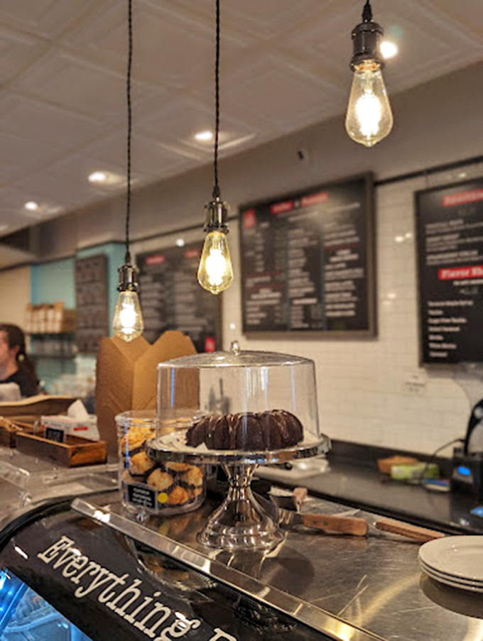 Edison bulbs cast a warm glow over freshly baked treats, while a chocolate bundt cake stands guard like a delicious sentinel.