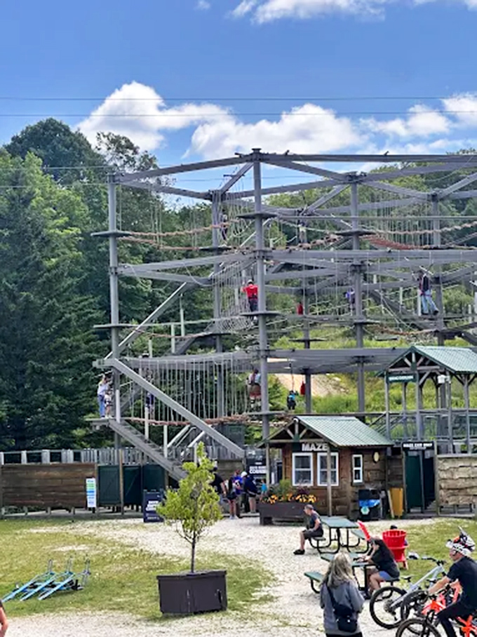 Participants navigate the multi-level structure against Vermont's rolling landscape, creating a striking contrast of adventure and serenity.