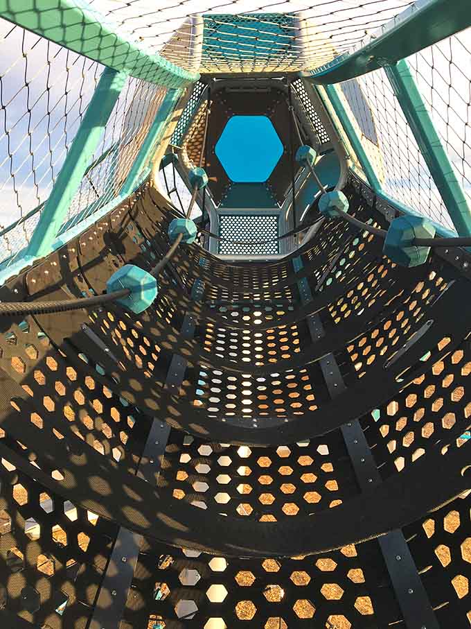 Inside the hexagonal tower, kids discover a whole new perspective on playground fun, like being inside a kaleidoscope made of adventure.