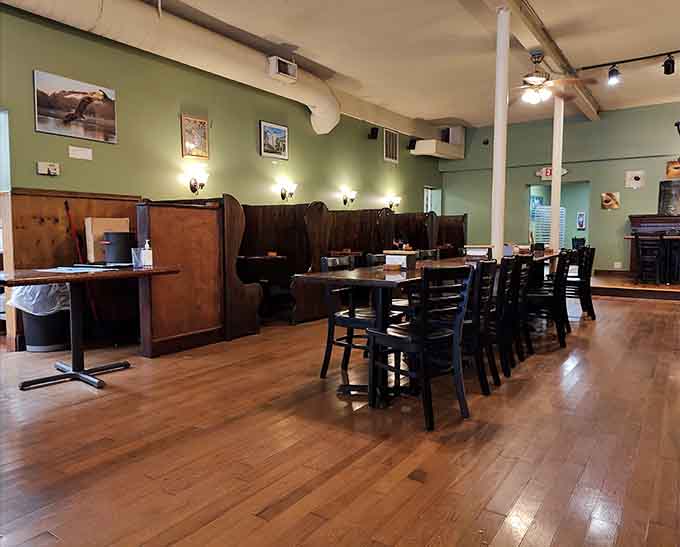Wooden booths and sage green walls create a cozy atmosphere where the hardest decision is choosing between a booth and a table.