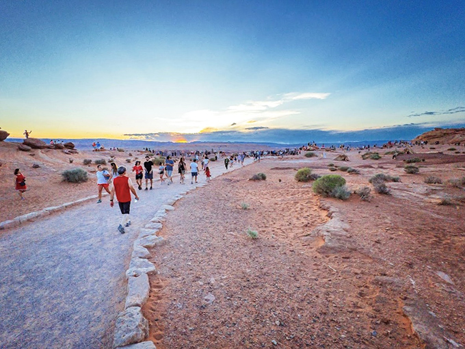 The path to wonder! Visitors trek along the sandy trail to Horseshoe Bend as sunset approaches, creating a pilgrimage-like atmosphere.