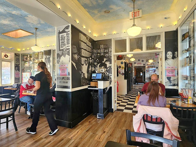 Step back in time with this retro interior where cloud-painted ceilings and vintage photos create the perfect backdrop for ice cream memories.