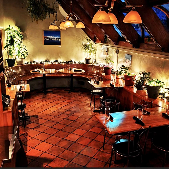 Skylights flood the solarium dining area with natural light, creating a greenhouse effect where plants thrive and conversations flow as freely as the cocktails.