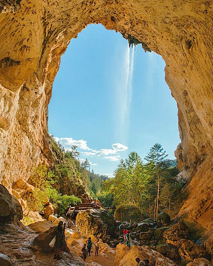 Sunlight streams through nature's skylight, illuminating the cathedral-like chamber where water and time have collaborated on their masterpiece.