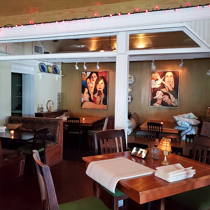 Warm lighting and artistic flair create an intimate dining atmosphere where conversations flow as freely as the wine.