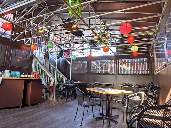 Colorful paper lanterns dance overhead in this cozy dining space where every table feels like the best seat in the house.