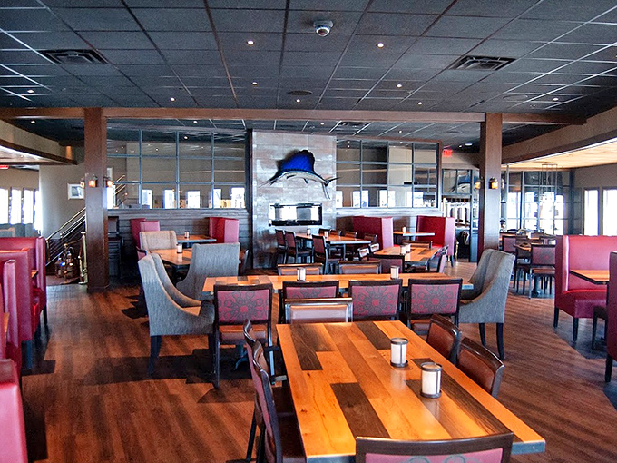 The warm wood-toned dining room offers panoramic harbor views, where every table feels like the captain's table.