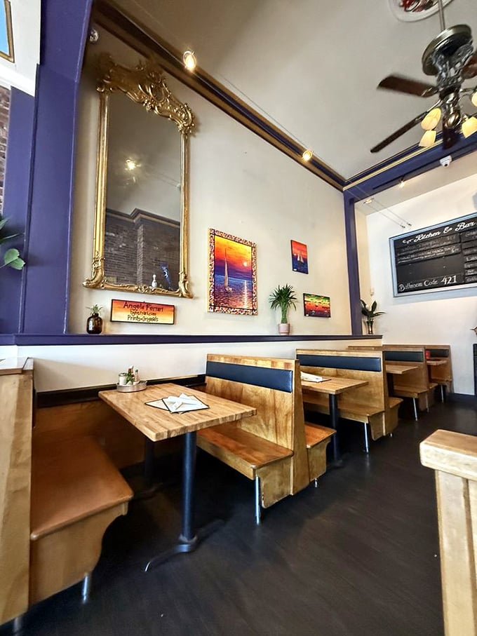 Wooden booths and gold-framed mirrors create an intimate setting where New England charm meets Southern hospitality.