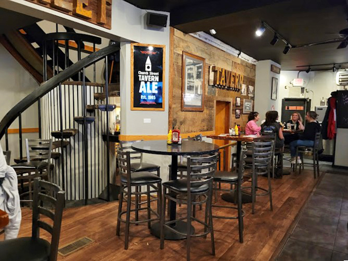 Rustic wooden walls and a spiral staircase create the perfect blend of cozy New England charm and modern tavern atmosphere. 