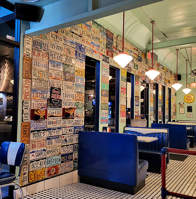 License plates from across America create a road-trip mosaic against blue vinyl booths &ndash; history you can touch.