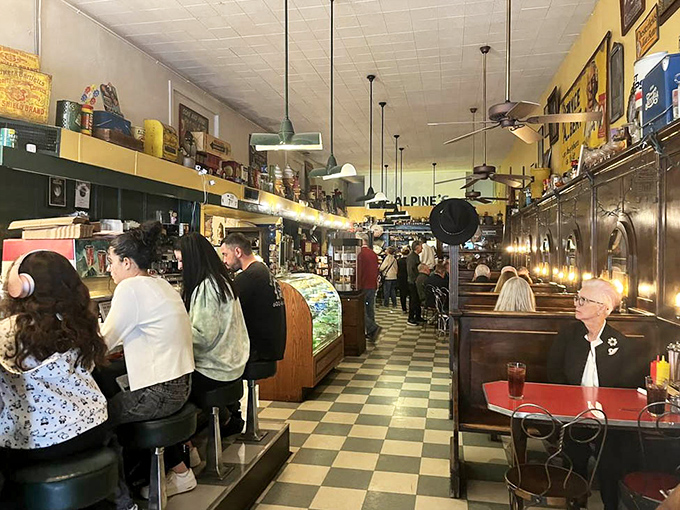 Classic black and white checkered floors lead the eye down a bustling aisle where history and hospitality have mingled for decades.