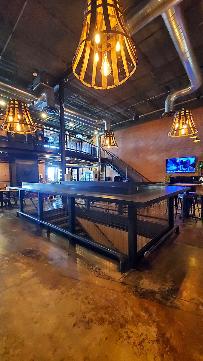 Industrial-chic meets cozy comfort inside 12 West, where wooden barrel-inspired pendant lights cast a warm glow over exposed brick and polished concrete.