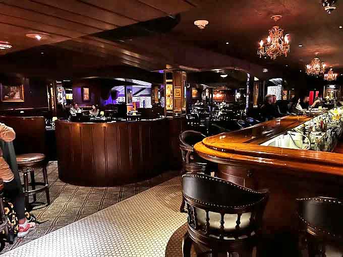 Warm wood paneling, intimate lighting, and a curved bar create the perfect backdrop for memorable evenings, where conversations flow as smoothly as the expertly crafted cocktails.