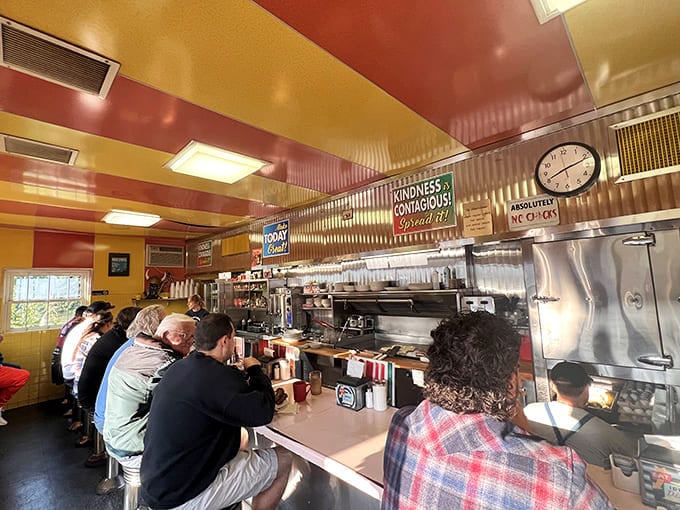 The counter seating offers the best show in town, where eggs crack and hash sizzles while that classic clock keeps time above the organized chaos.