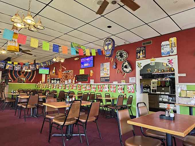 Interior: Colorful papel picado banners dance above tables where culinary magic happens daily. The festive atmosphere promises a fiesta for your taste buds.