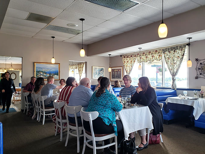 Blue booths meet white tablecloths in a dining room where comfort and elegance shake hands and become friends.