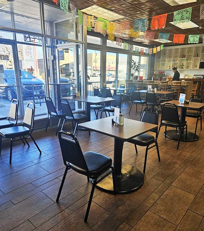 Festive papel picado banners and natural light create a welcoming space where comfort meets authentic Mexican hospitality every single day.