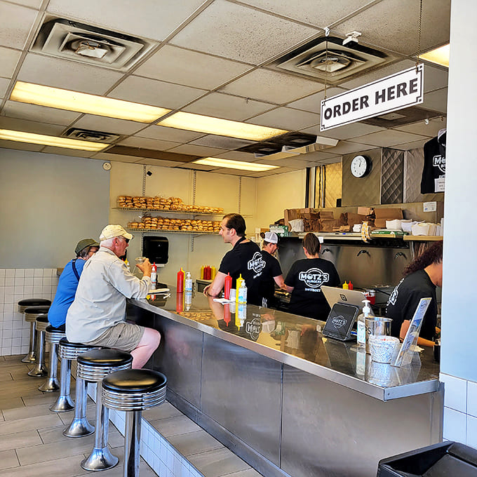 The heart of slider magic: Motz's counter where patrons perch on chrome stools, watching culinary history unfold with each patty.
