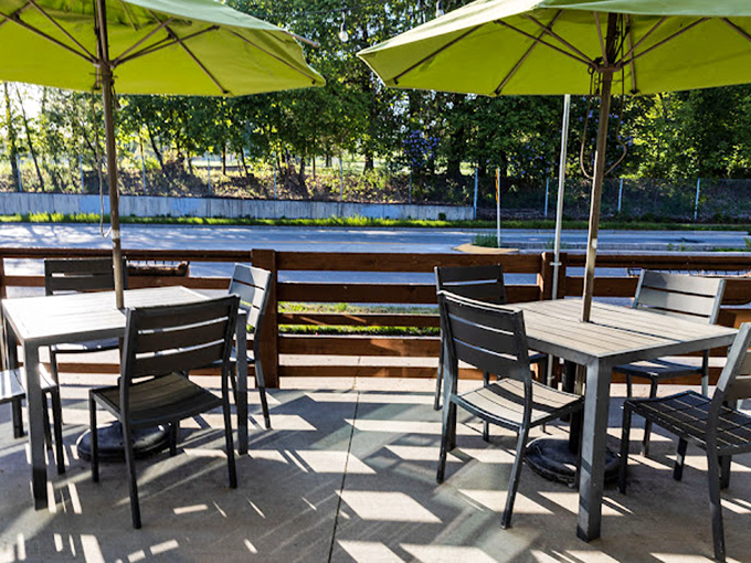 Al fresco dining under cheery green umbrellas. People-watching paradise meets culinary heaven in this inviting outdoor space.